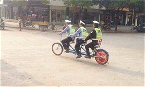 Small town police patrol on tandem bicycle built for three - Global Times