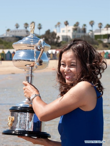 Li Na poses with trophy on Brighton Beach in Melbourne - Global Times