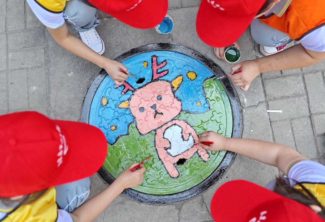 Students paint give manhole covers makeovers in China’s Qinhuangdao ...