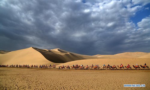 Tourists visit Mingsha Mountain and Crescent Spring scenic spot in ...