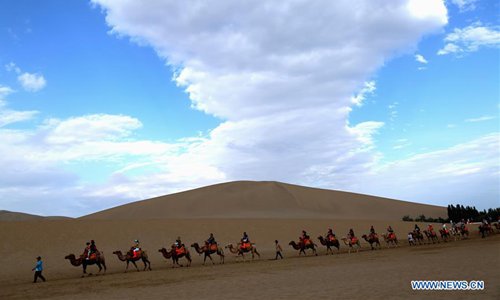 Tourists visit Mingsha Mountain and Crescent Spring scenic spot in ...