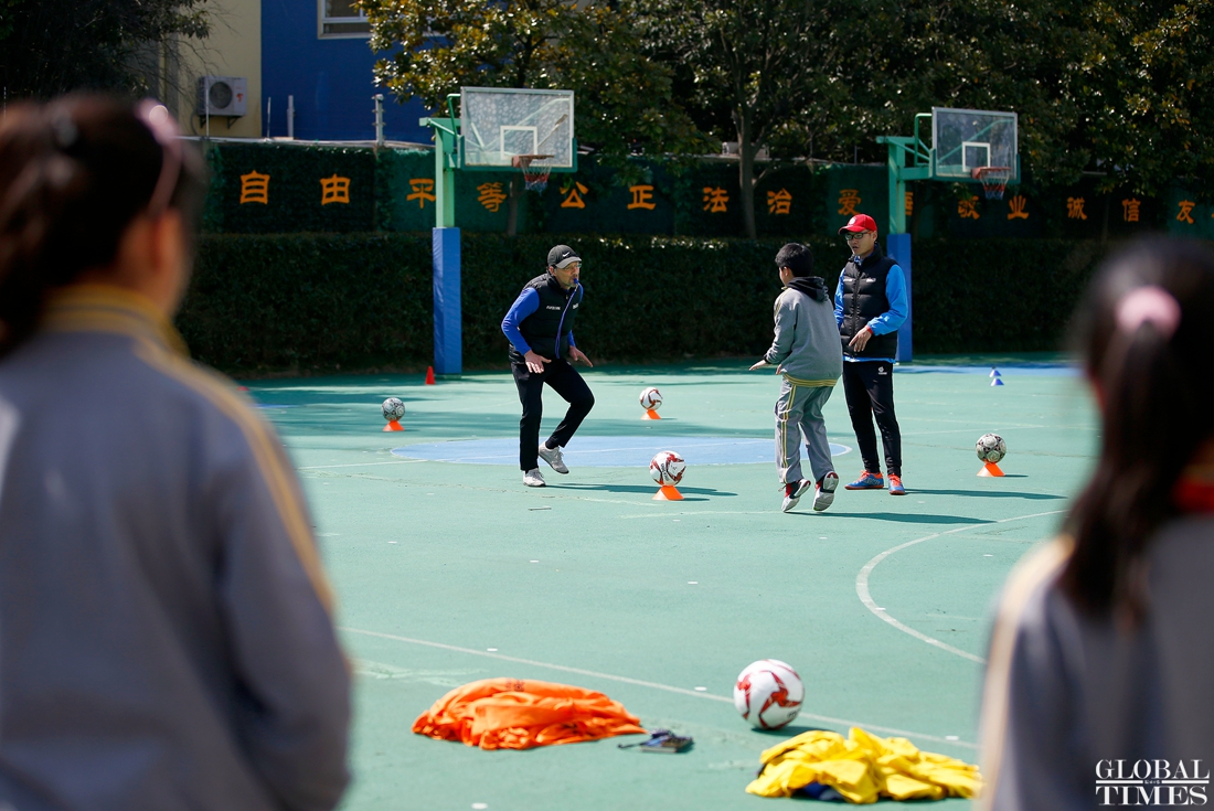 Foreign coaches teach football classes to students at schools in ...