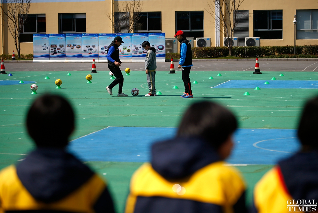 Foreign coaches teach football classes to students at schools in ...