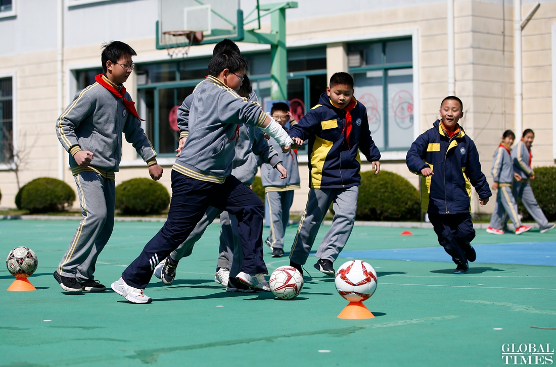 Foreign coaches teach football classes to students at schools in ...