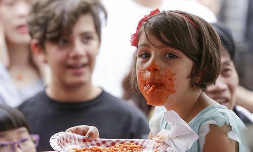 Girls participate in spaghetti eating contest during Italian Day ...