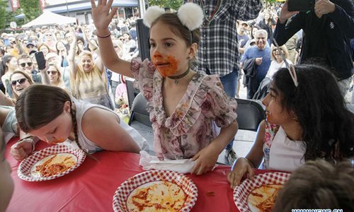 Girls participate in spaghetti eating contest during Italian Day ...