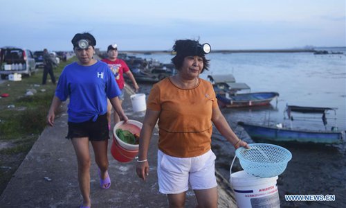 People join in beachcombing for shells along seaside of Qingge Port in ...