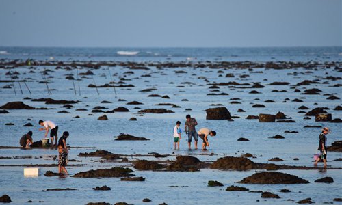 People join in beachcombing for shells along seaside of Qingge Port in ...
