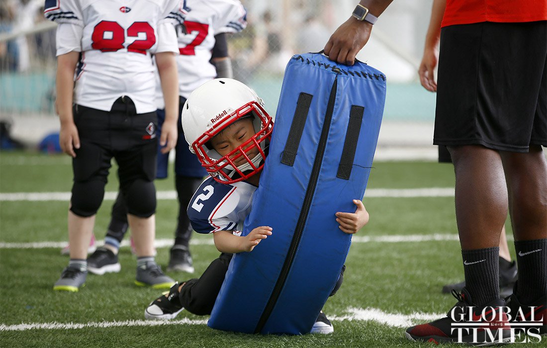Children revel their summer vacation days with American football ...