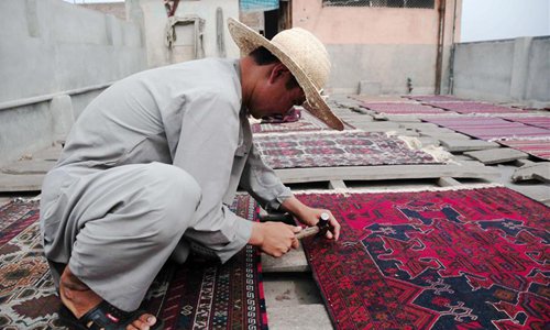 Pakistani workers make carpet at carpet factory in Peshawar - Global Times
