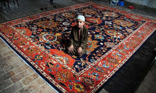 Pakistani workers make carpet at carpet factory in Peshawar - Global Times