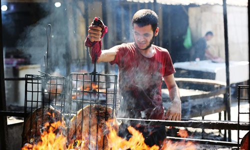 Men make grilled fish at shop in Baghdad, Iraq - Global Times