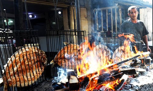 Men make grilled fish at shop in Baghdad, Iraq - Global Times