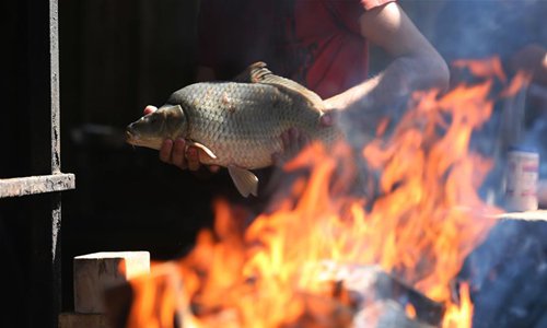 Men make grilled fish at shop in Baghdad, Iraq - Global Times