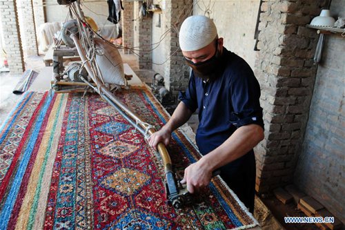 Pakistani workers make carpet at carpet factory in Peshawar - Global Times