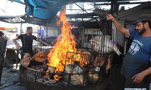 Men make grilled fish at shop in Baghdad, Iraq - Global Times