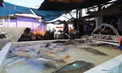 Men make grilled fish at shop in Baghdad, Iraq - Global Times