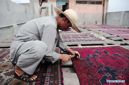 Pakistani workers make carpet at carpet factory in Peshawar - Global Times