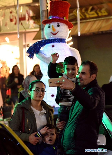People look at decorations of holiday season in Damascus, Syria ...