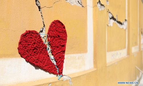 Knitted heart on crack of building damaged by earthquakes in Croatia ...