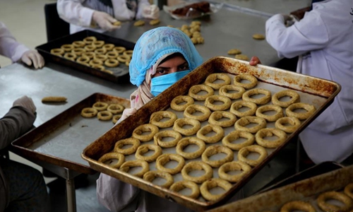 Palestinians prepare traditional cookies for sale ahead of Eid al-Fitr ...