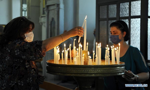 Worshipers light candles during prayers held to greet medics fighting ...