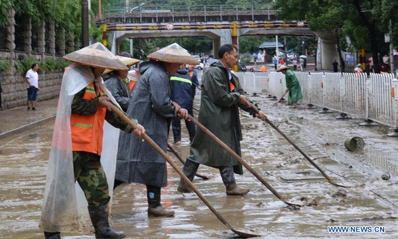 Workers clean up mud-covered roads after flood recedes in Jishou City ...