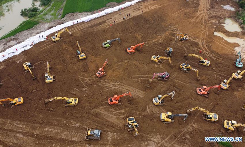 Heavy machineries work to build temporary embankment to prevent ...
