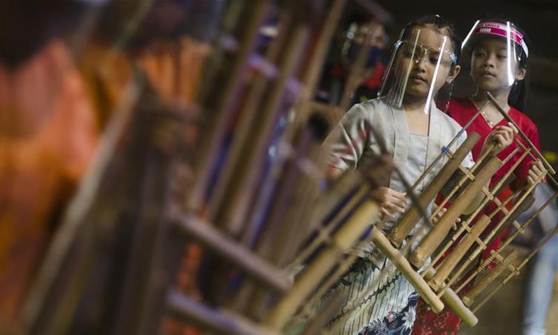 Children wearing face mask play traditional music instrument of ...