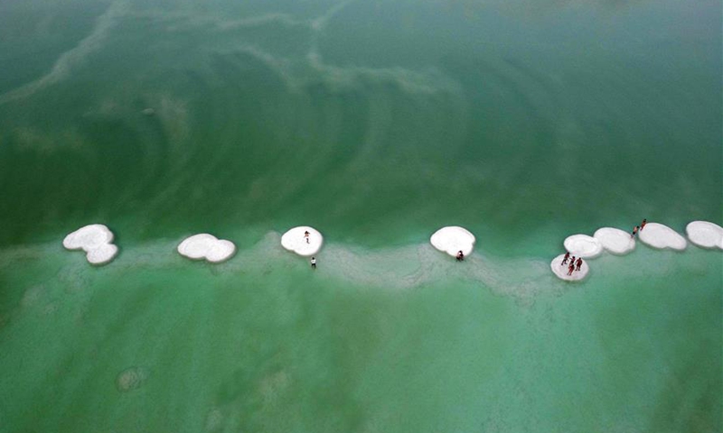 People stand on salt formations in Dead Sea near Ein Bokek, Israel - Global Times