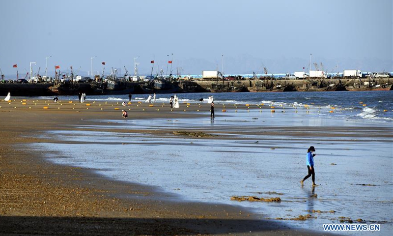 People enjoy themselves on beach of scenic area in Rizhao, E China ...
