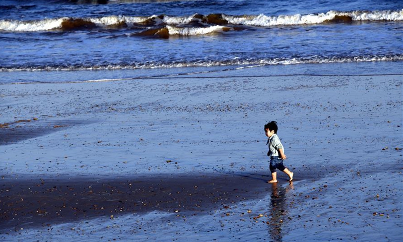 People enjoy themselves on beach of scenic area in Rizhao, E China ...