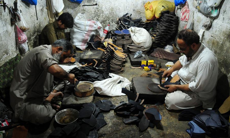 Workers make traditional shoes at shop in Pakistan's Peshawar - Global ...