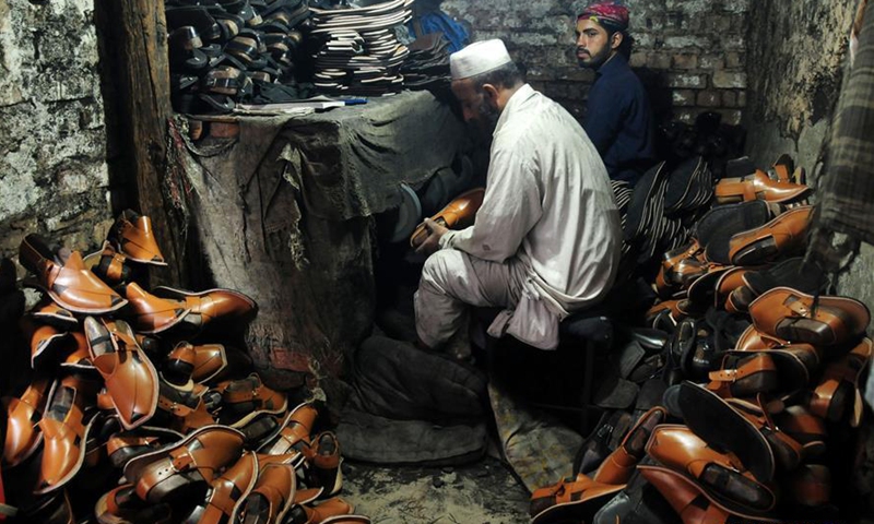 Workers make traditional shoes at shop in Pakistan's Peshawar - Global ...