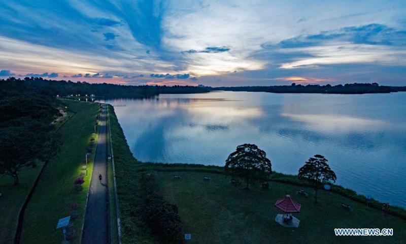 People take evening walks along Upper Seletar Reservoir in Singapore ...