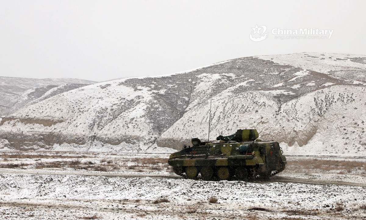 Armored vehicles rumble on snow-covered road - Global Times