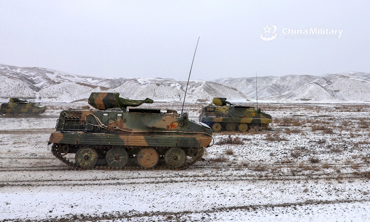 Armored vehicles rumble on snow-covered road - Global Times