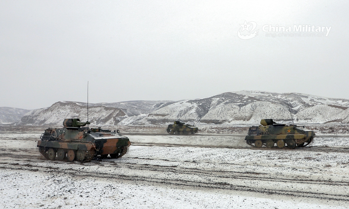 Armored vehicles rumble on snow-covered road - Global Times