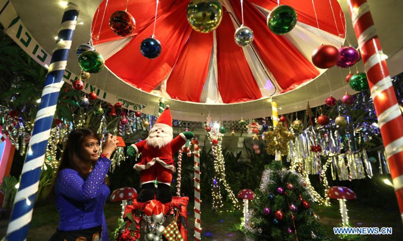 Visitors pose for photos with Christmas decorations in Yangon, Myanmar ...