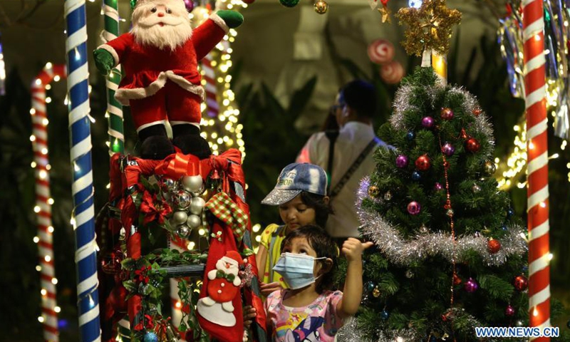 Visitors pose for photos with Christmas decorations in Yangon, Myanmar ...