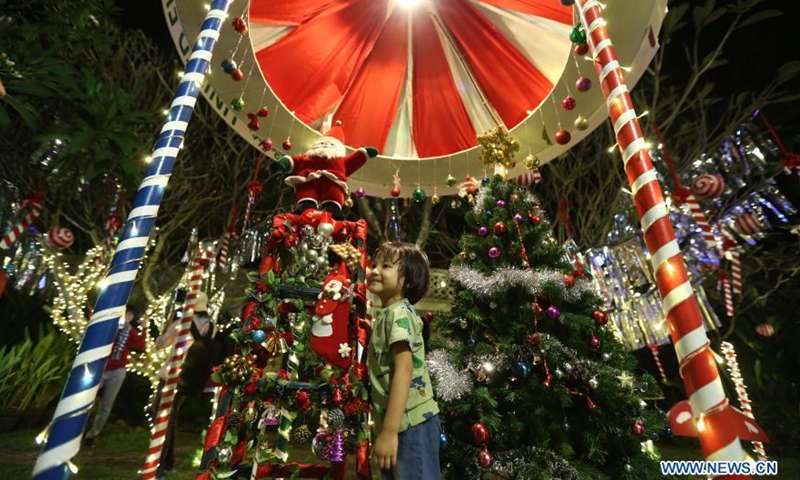 Visitors pose for photos with Christmas decorations in Yangon, Myanmar ...