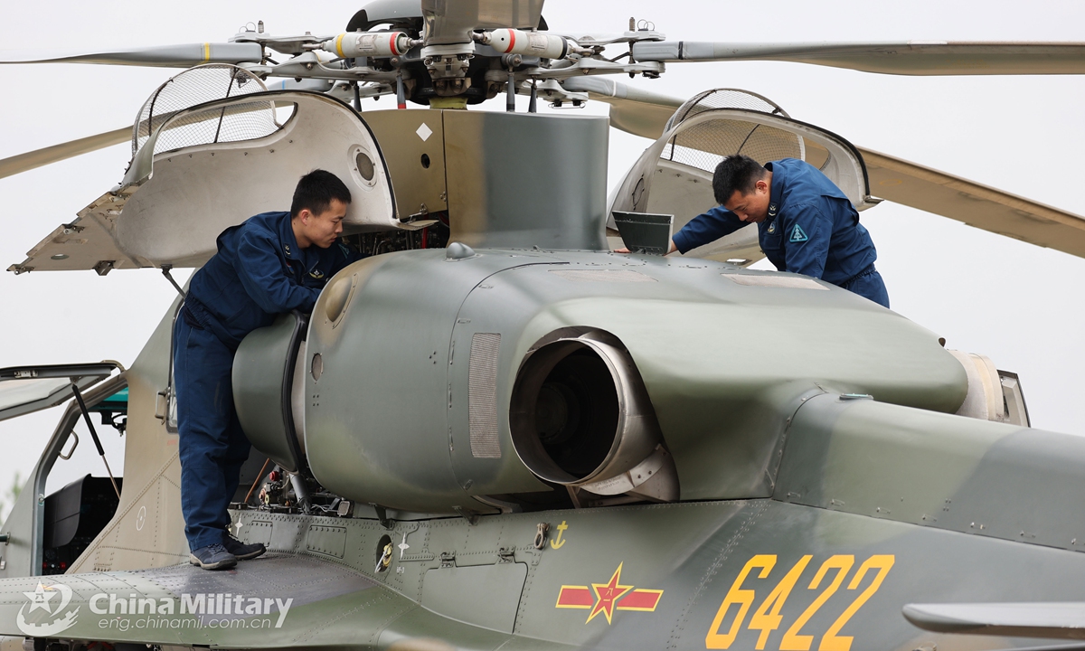 Maintenance men perform inspections on helicopter - Global Times