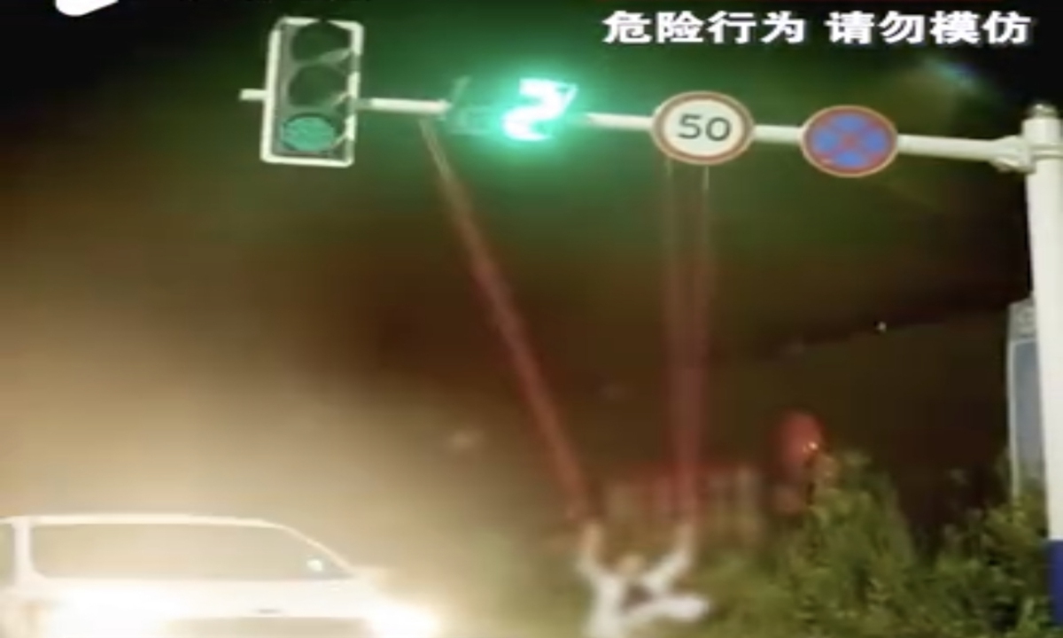 Man swinging under a traffic light in East China sparks criticism ...