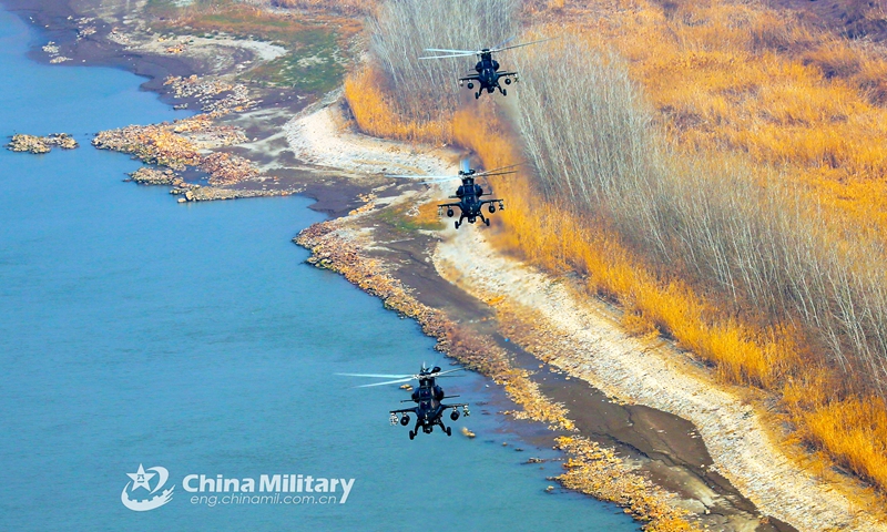 Attack helicopters fly over river bank - Global Times