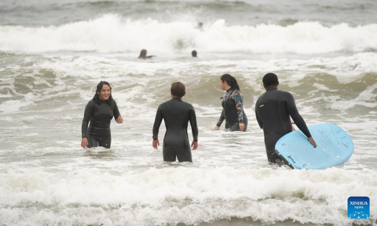 People surf amid high temperature at Pacifica Beach in north California ...