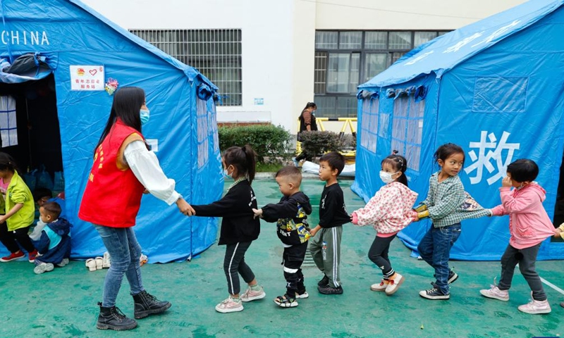 Volunteers open tent classrooms for children at quake relief shelter in ...