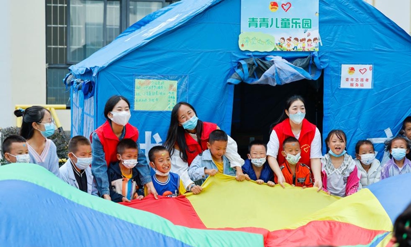 Volunteers open tent classrooms for children at quake relief shelter in ...