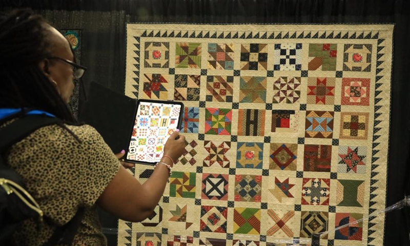 Visitors look at quilts during Houston International Quilt Festival ...