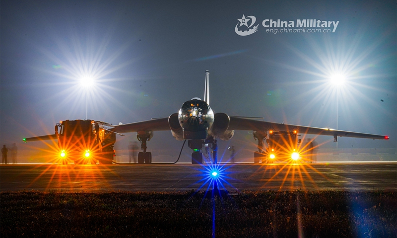 Airman guides aircraft at night - Global Times