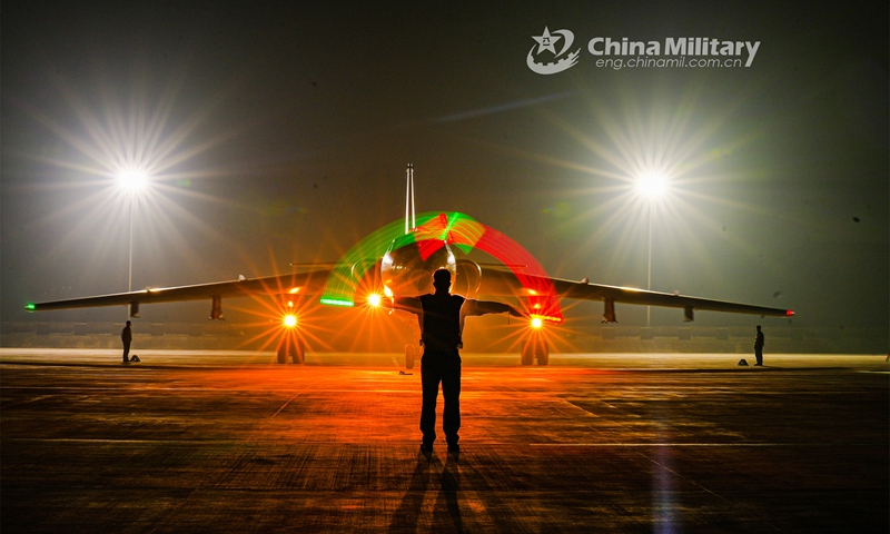 Airman guides aircraft at night - Global Times